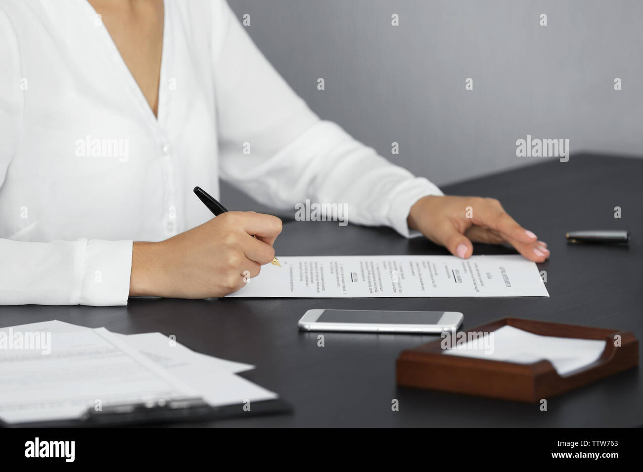Woman signing important document in modern office Stock Photo - Alamy