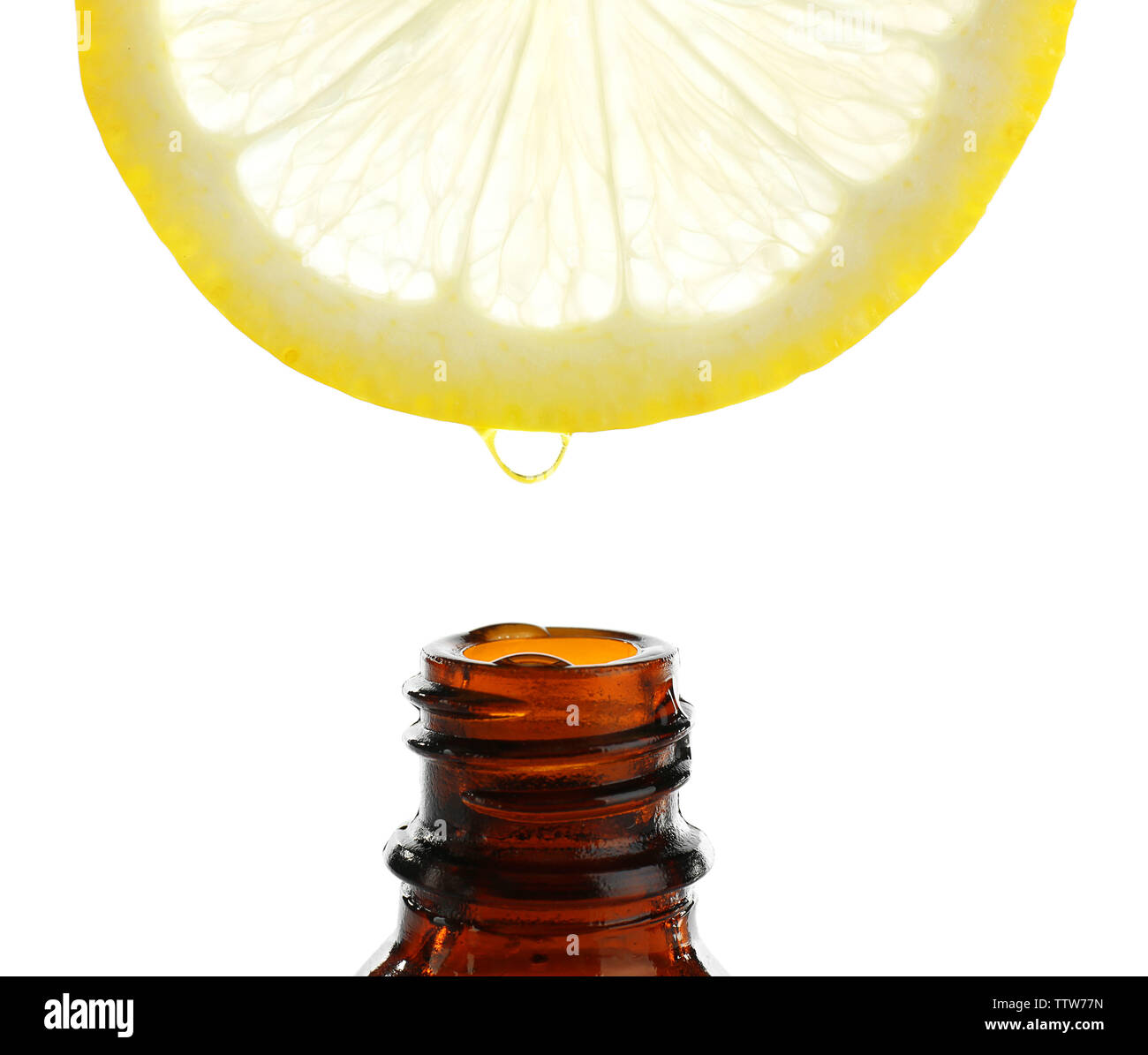 Slice of lemon with glass bottle and essential oil on white background ...