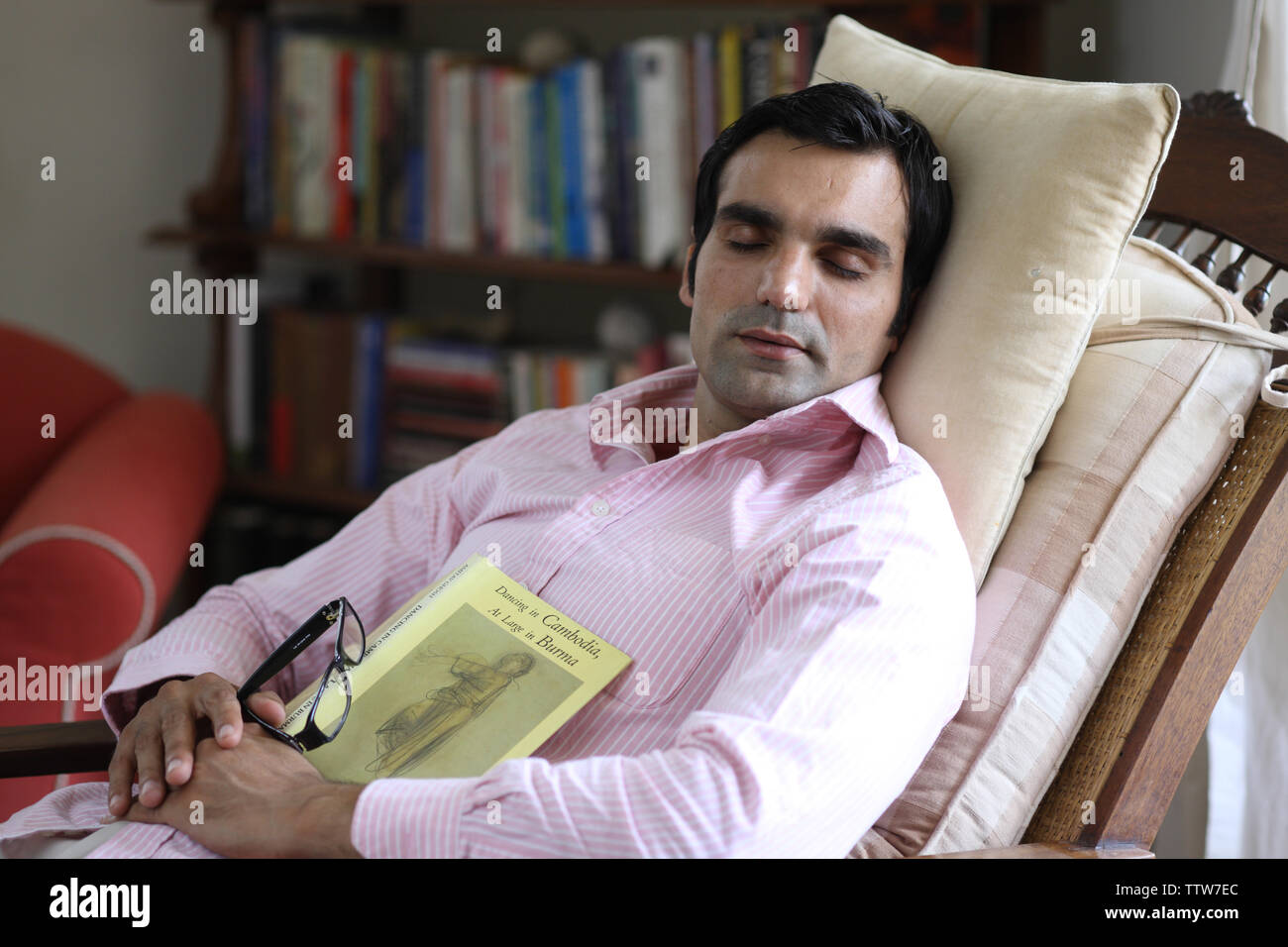 Indian young man napping on a reclining chair Stock Photo - Alamy