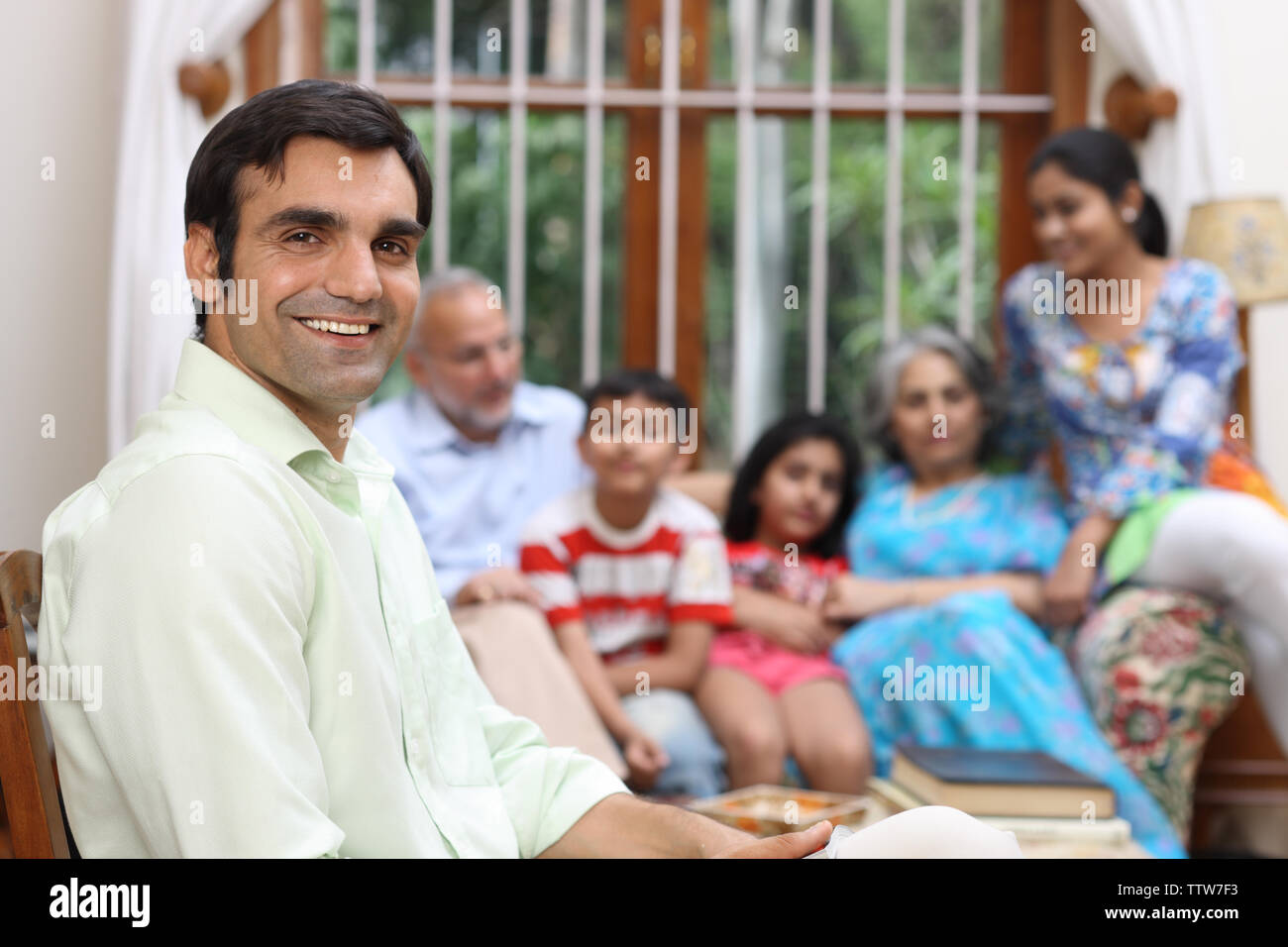 Portrait of a man smiling with his family in the background Stock Photo ...