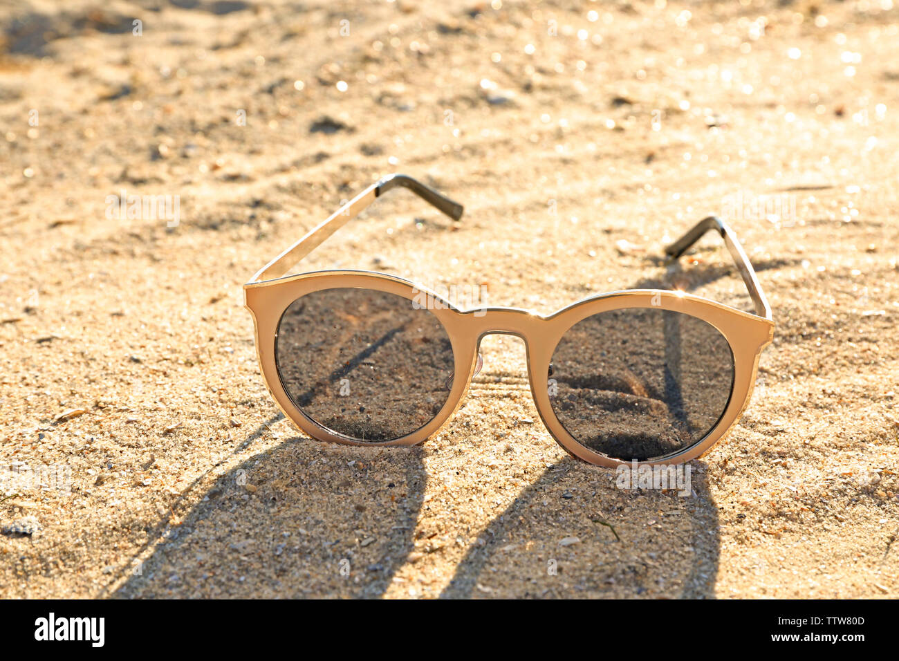 Sunglasses on sand beach, close up view Stock Photo - Alamy