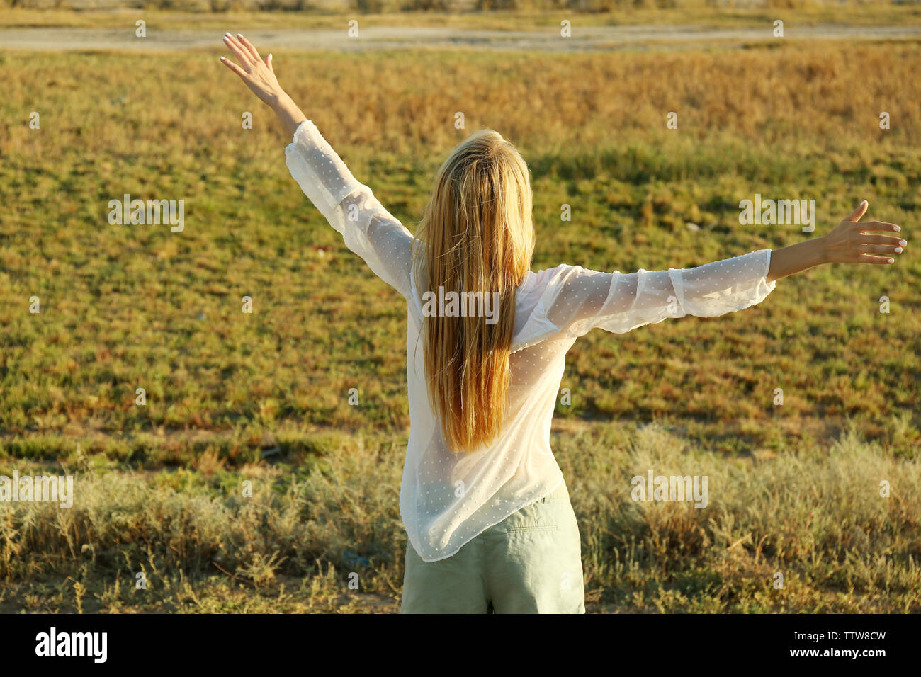 Young woman walking on field background Stock Photo - Alamy