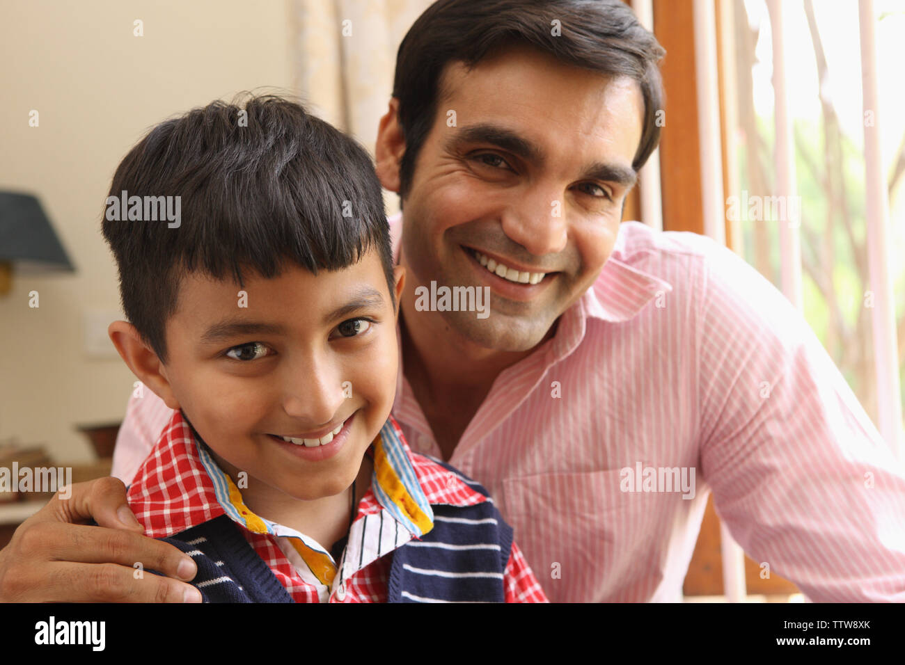 Portrait of a man with his son smiling Stock Photo - Alamy