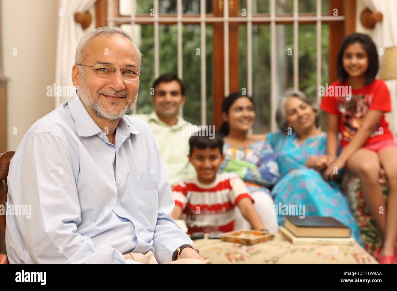 Portrait of a man with family in the background Stock Photo - Alamy
