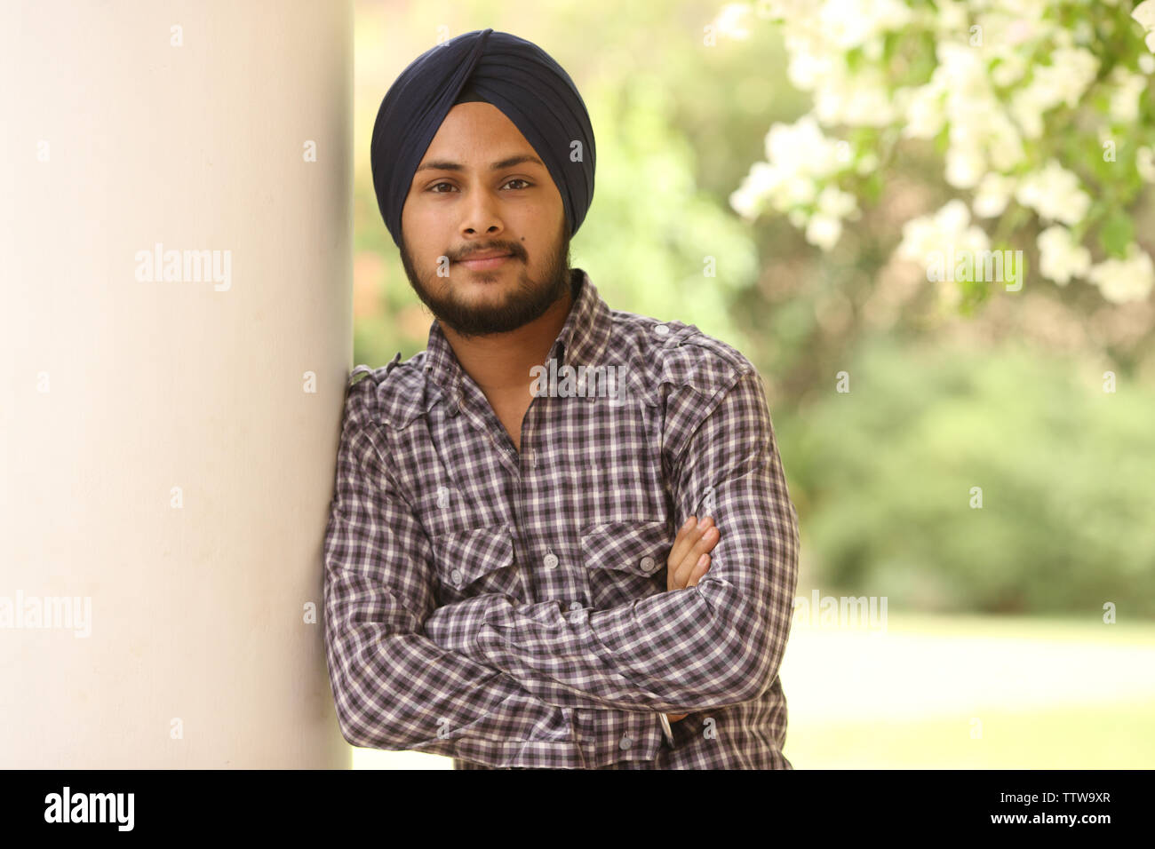 Portrait of a man leaning against a pole Stock Photo - Alamy