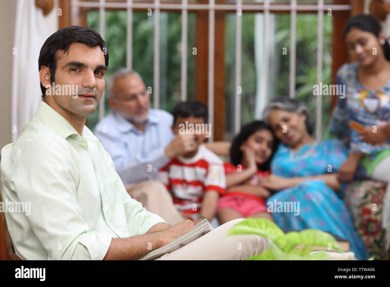 Portrait of a man with family in the background Stock Photo - Alamy