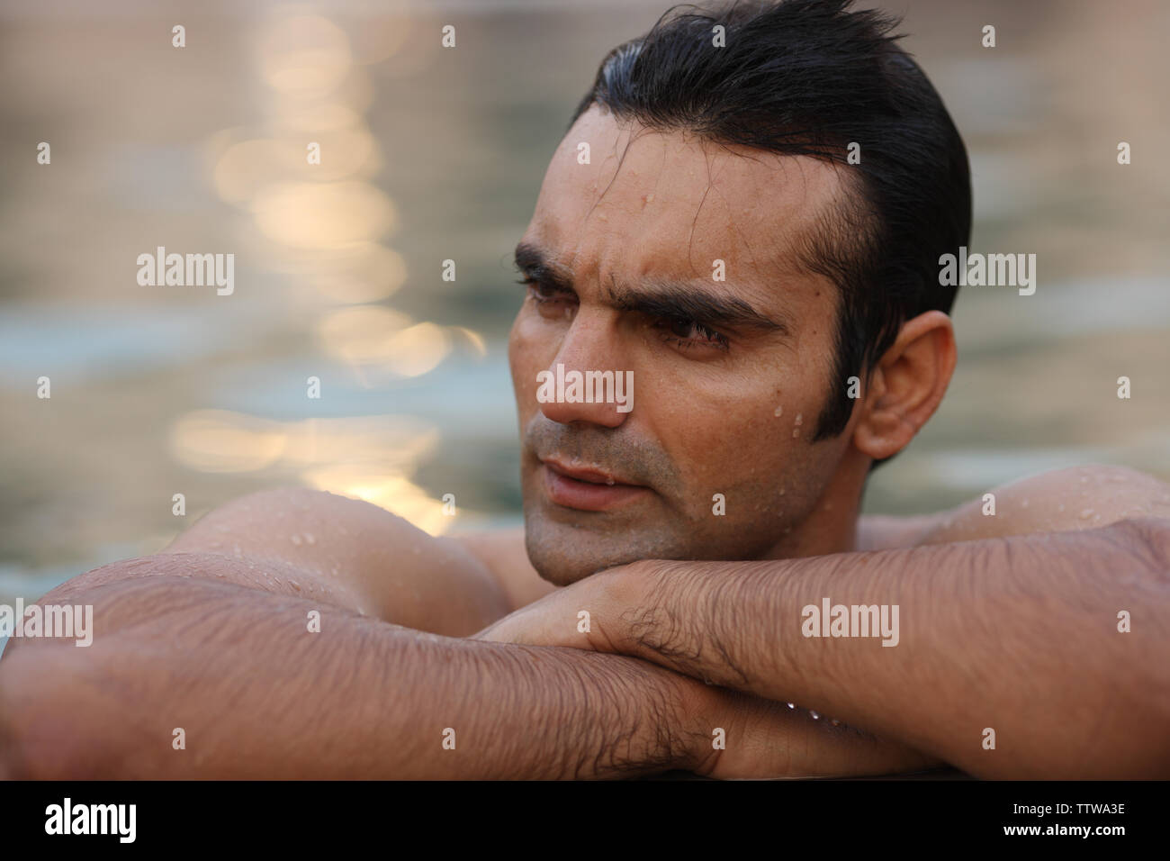 Man resting at the edge of pool Stock Photo - Alamy