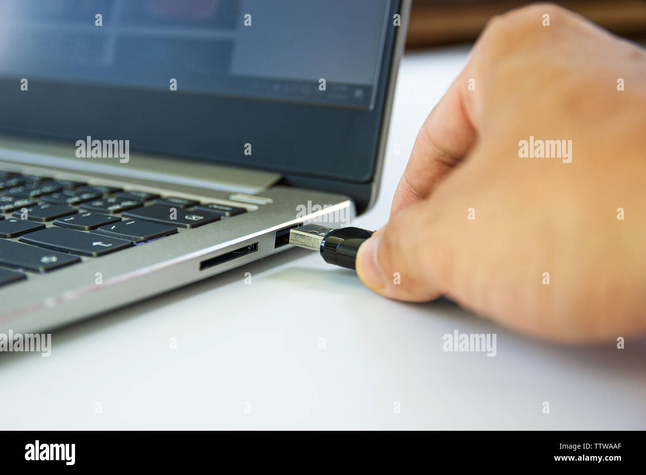 hand man connect flash drive to USB port plug-in computer laptop for ...