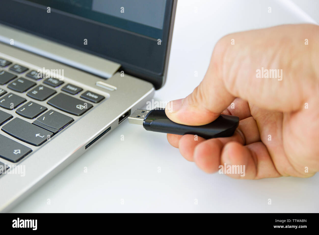 hand man connect flash drive to USB port plug-in computer laptop for ...