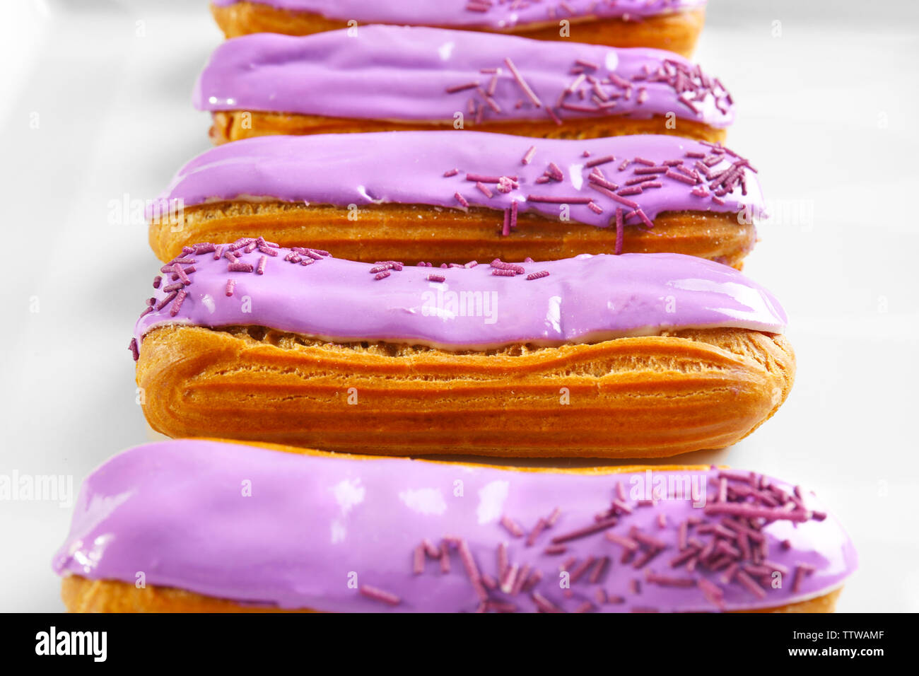 Delicious glazed eclairs on white background Stock Photo - Alamy