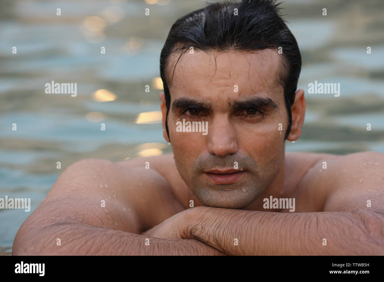 Man resting at the edge of pool Stock Photo - Alamy