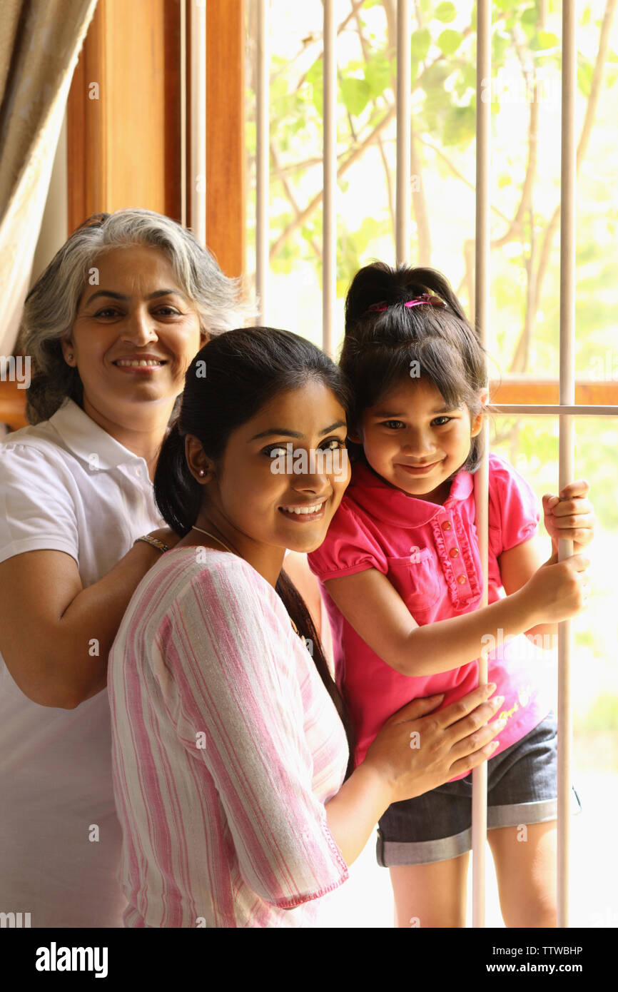 Family standing at a window Stock Photo - Alamy