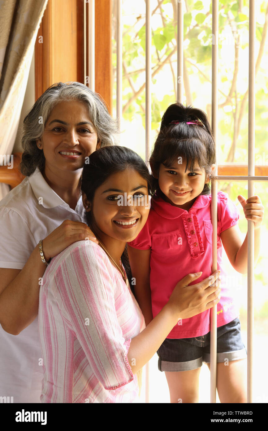 Family standing at a window Stock Photo - Alamy