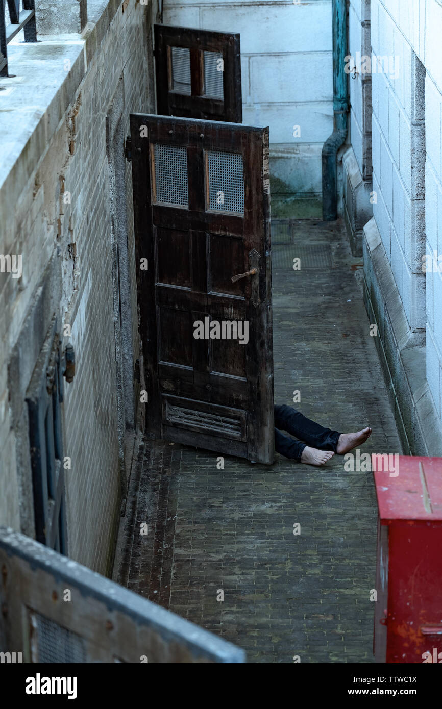 man with bare feet hiding behind an open door in a basement Stock Photo ...