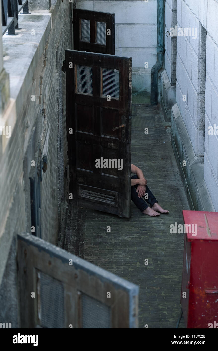 man with bare feet hiding behind an open door in a basement Stock Photo ...