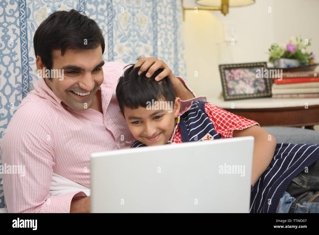Man with his son working on a laptop Stock Photo - Alamy