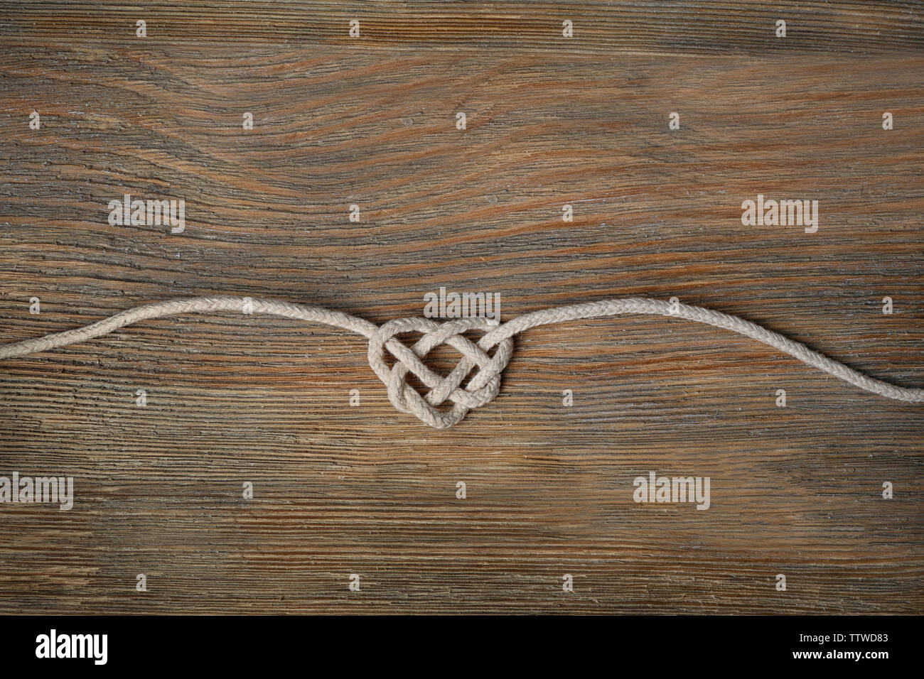 Heart shaped knot on wooden background Stock Photo - Alamy