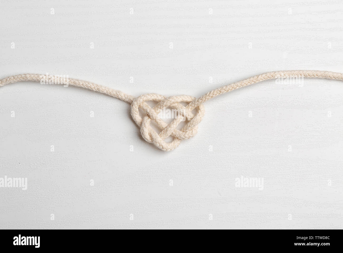 Heart shaped knot on wooden background Stock Photo - Alamy