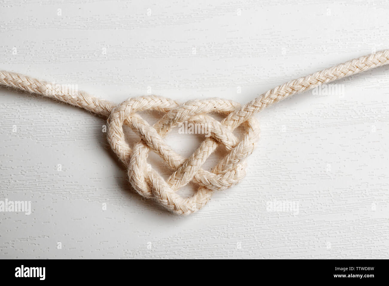 Heart shaped knot on wooden background Stock Photo - Alamy