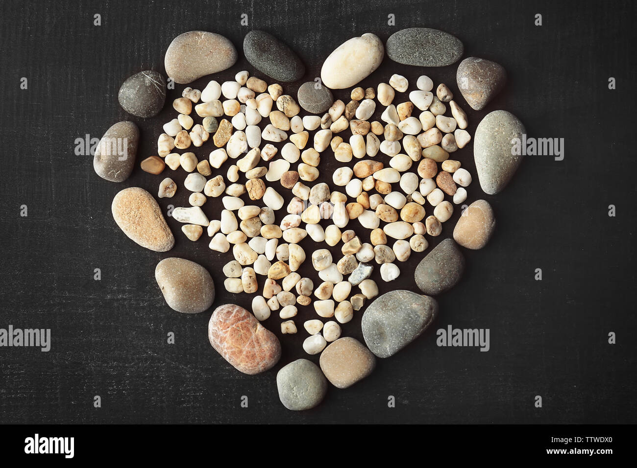 Beautiful heart made of big and small pebbles on dark background Stock ...