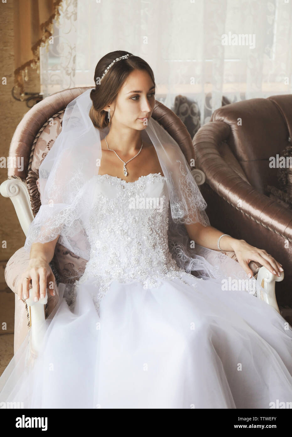 Beautiful bride sitting in vintage armchair Stock Photo - Alamy