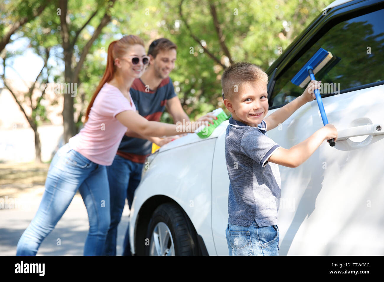 Happy family washing car on street Stock Photo - Alamy