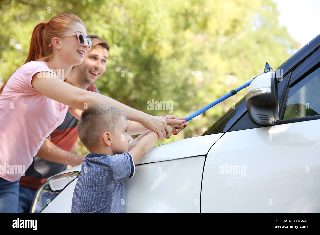 Happy family washing car on street Stock Photo - Alamy