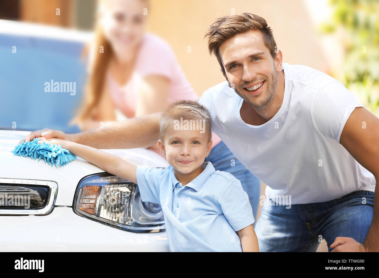 Happy family washing car on street Stock Photo - Alamy