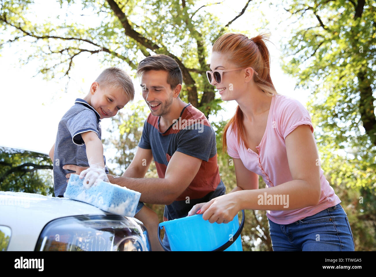 Happy family washing car on street Stock Photo - Alamy