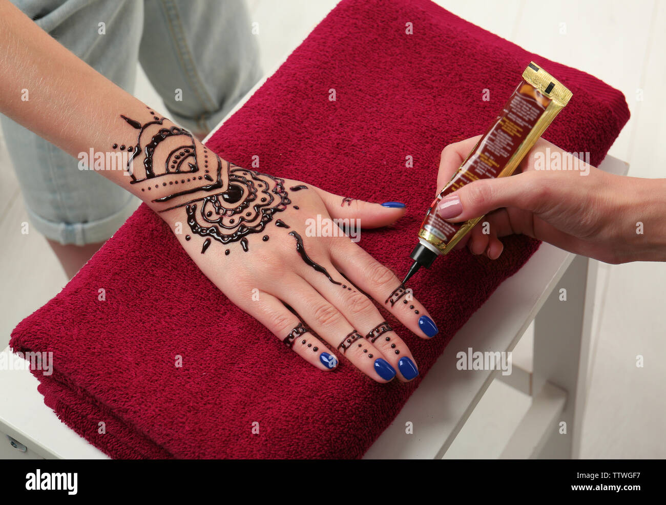 Woman applying henna on female hand Stock Photo - Alamy