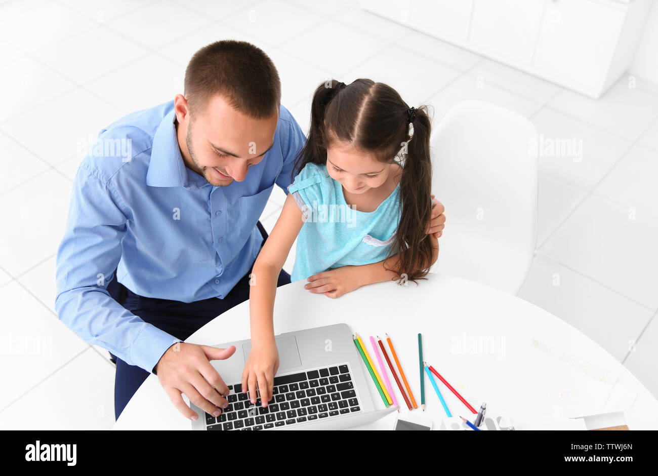 Daughter helping father working in office Stock Photo - Alamy