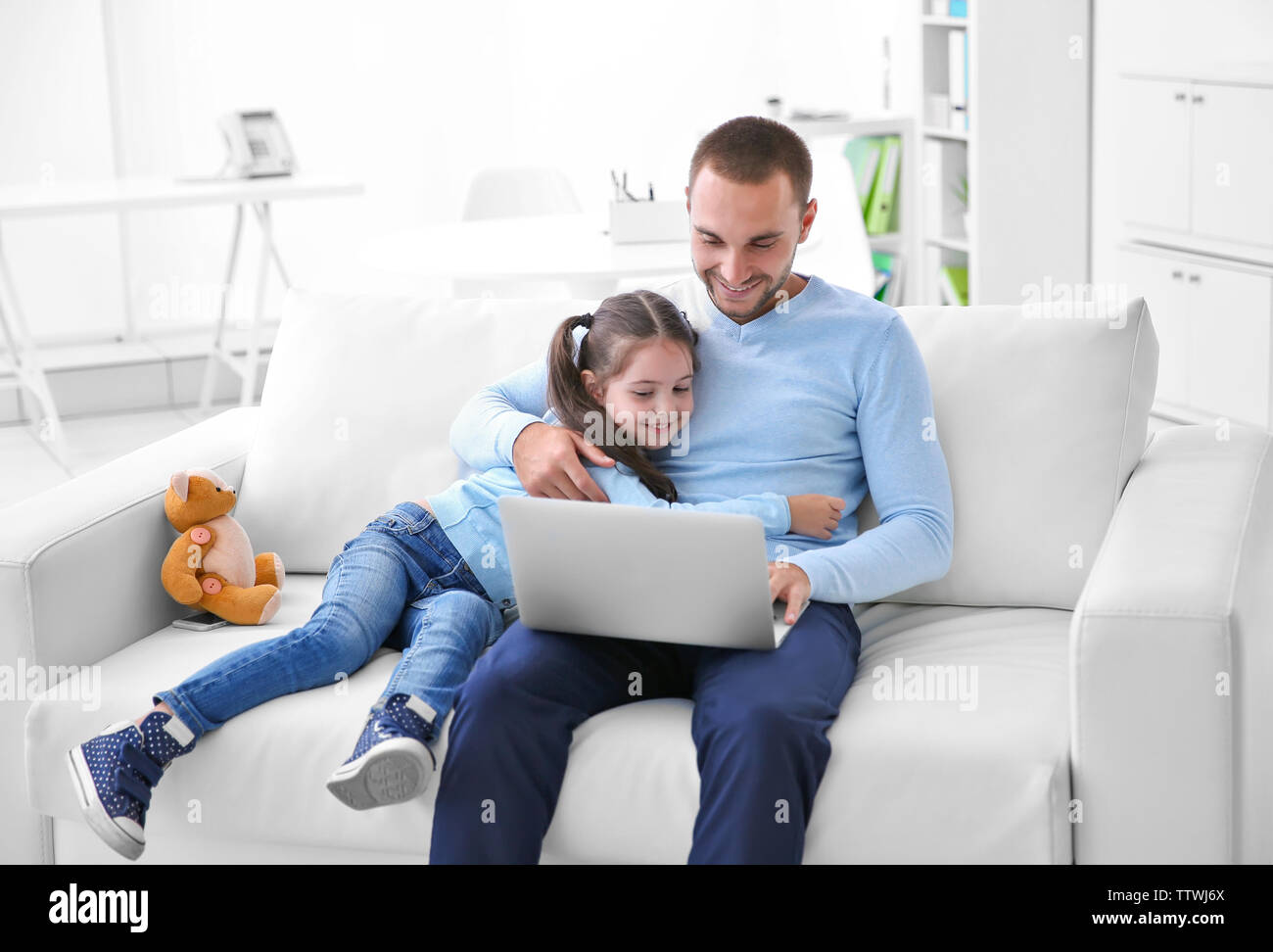Daughter helping father working at home Stock Photo - Alamy