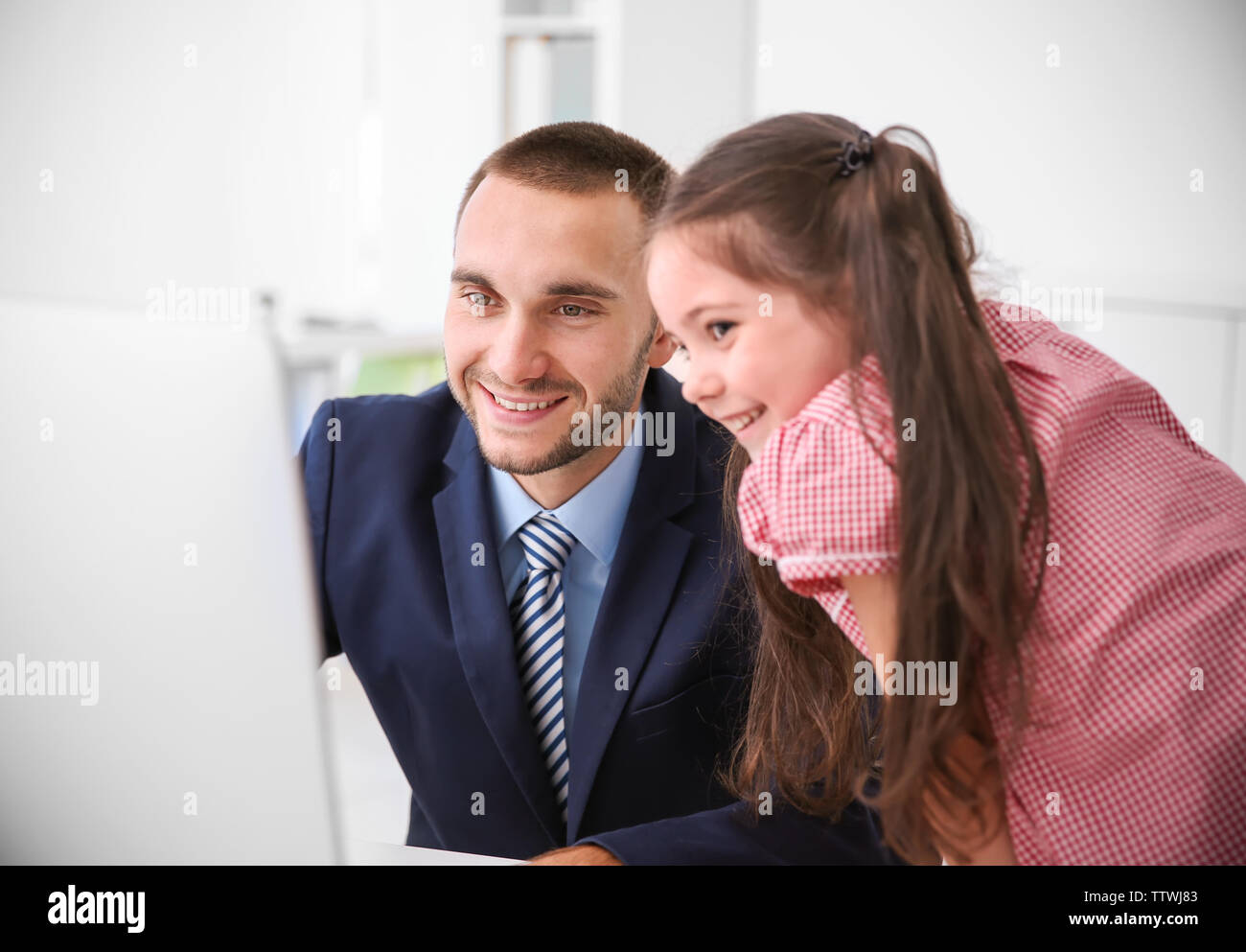 Daughter helping father working in office Stock Photo - Alamy