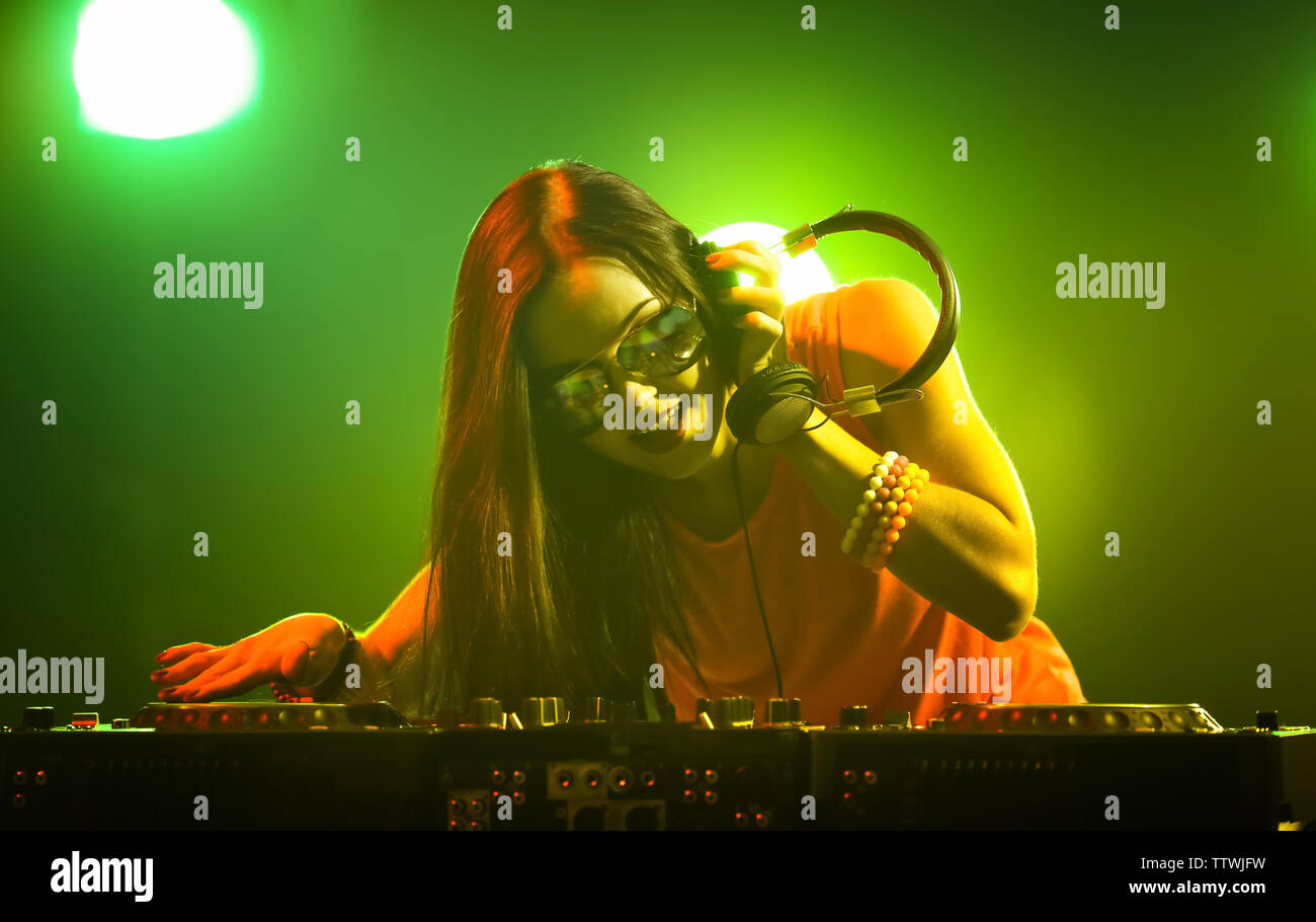 Pretty young DJ playing music in nightclub Stock Photo - Alamy