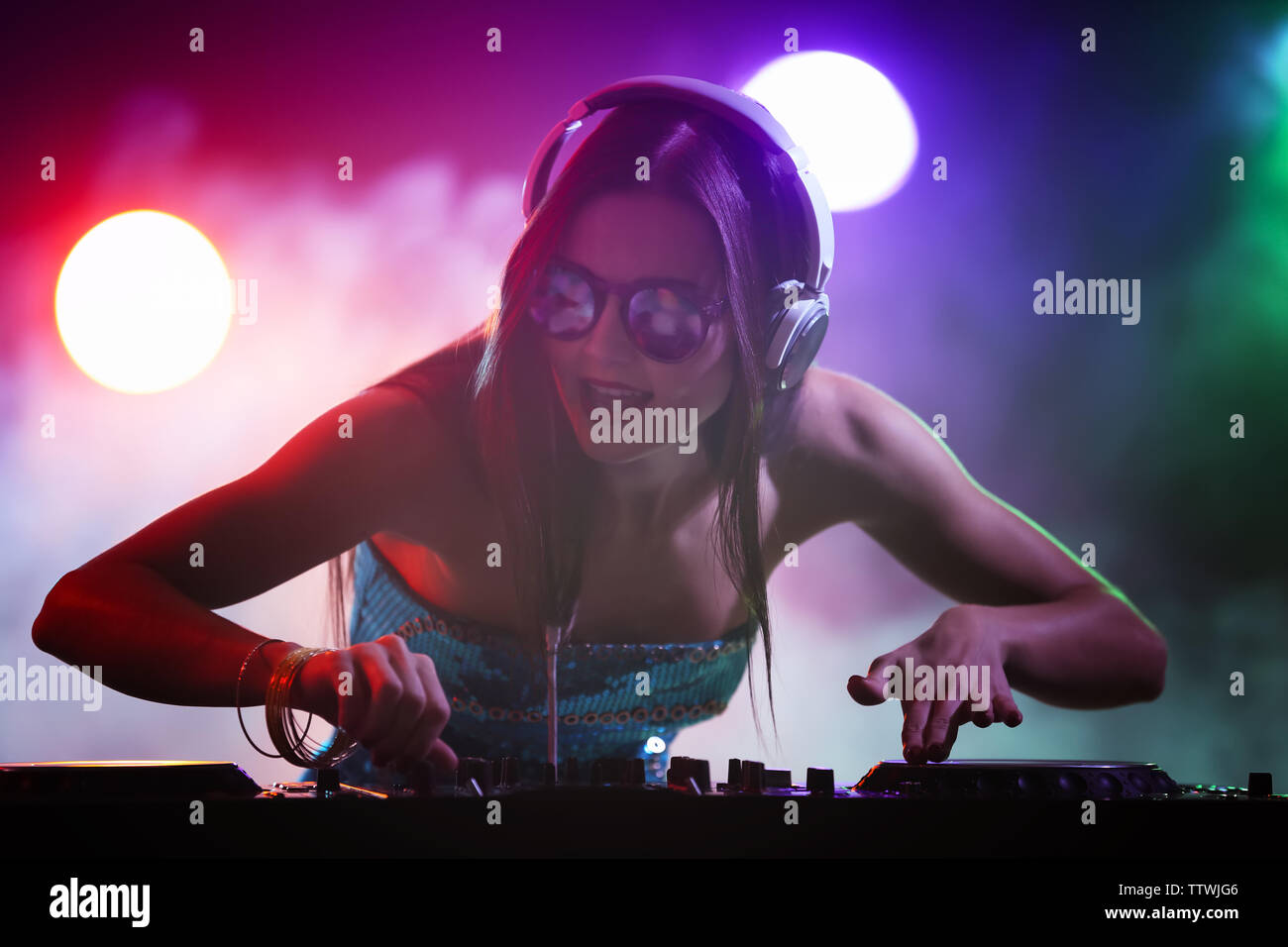 Pretty young DJ playing music in nightclub Stock Photo - Alamy