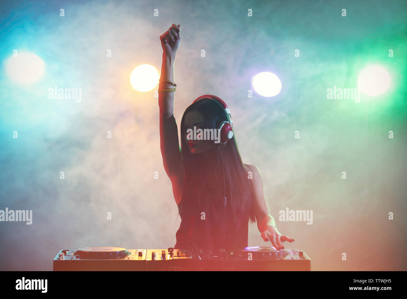 Pretty young DJ playing music in nightclub Stock Photo - Alamy