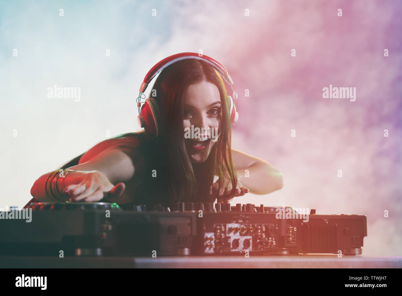 Pretty young DJ playing music in nightclub Stock Photo - Alamy
