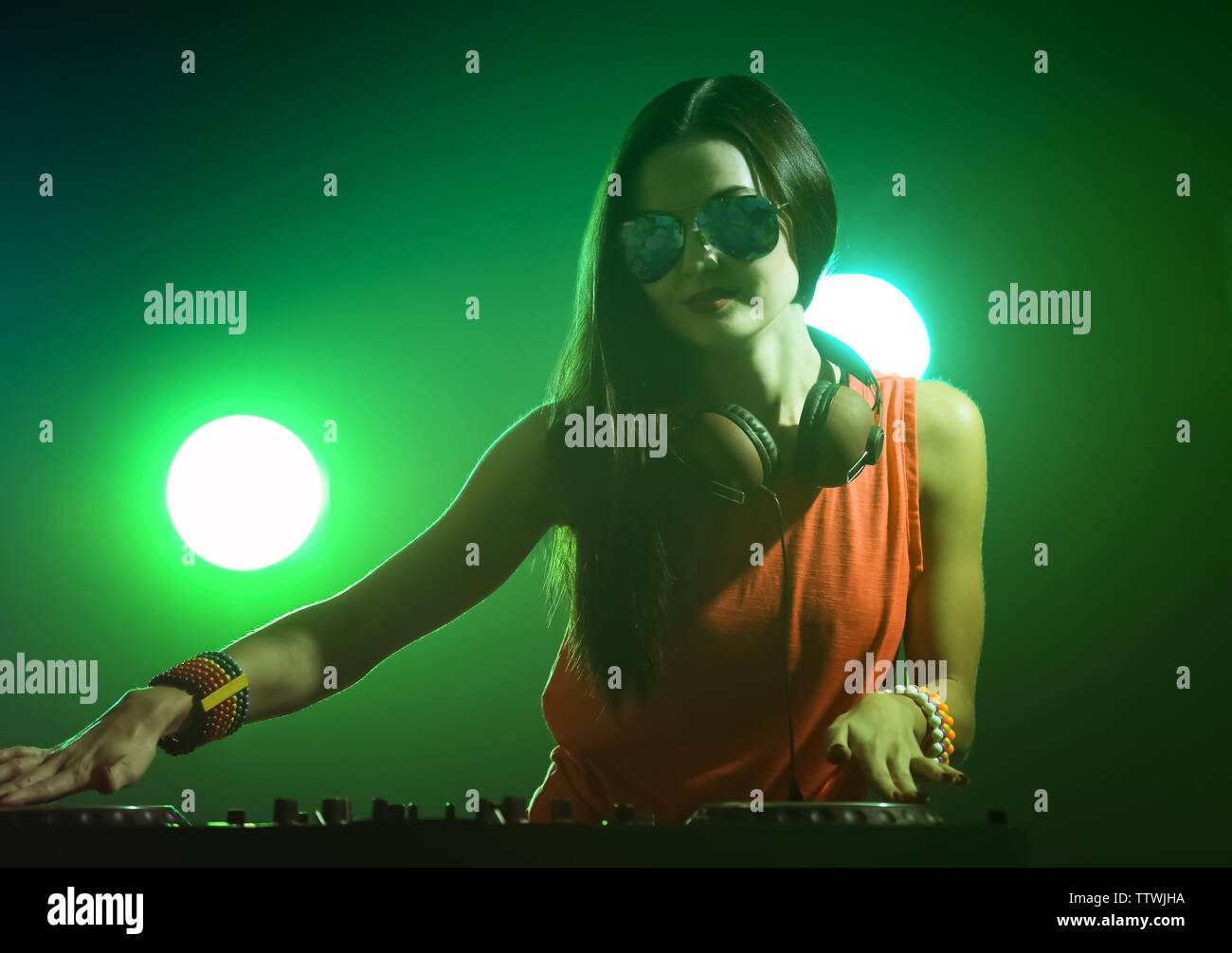 Pretty young DJ playing music in nightclub Stock Photo - Alamy