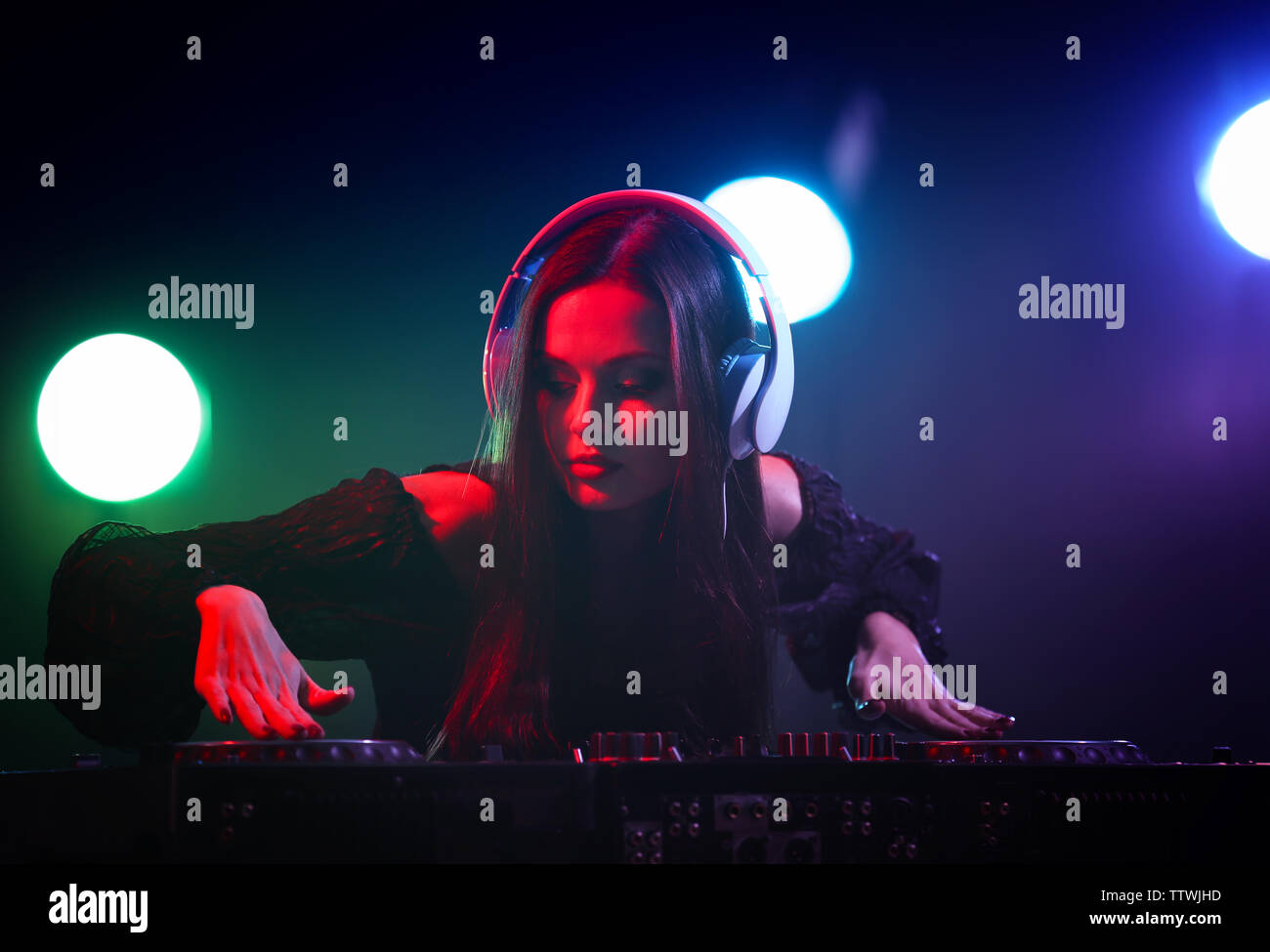 Pretty young DJ playing music in nightclub Stock Photo - Alamy