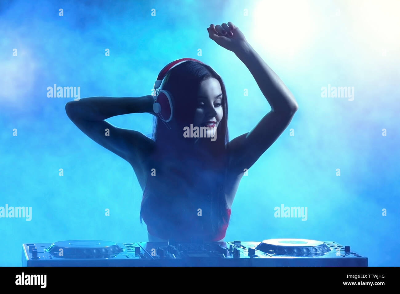 Pretty young DJ playing music in nightclub Stock Photo - Alamy