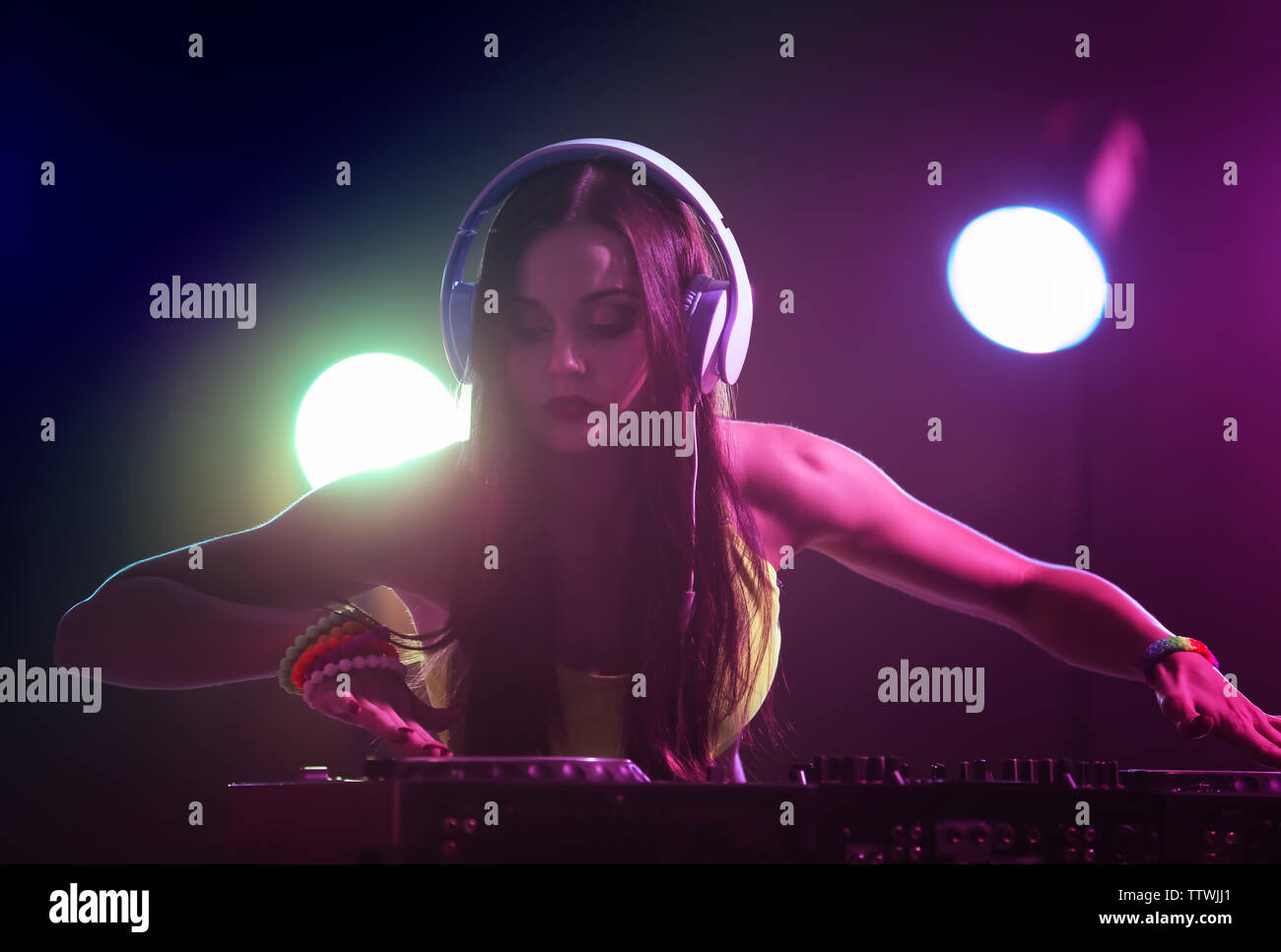 Pretty young DJ playing music in nightclub Stock Photo - Alamy