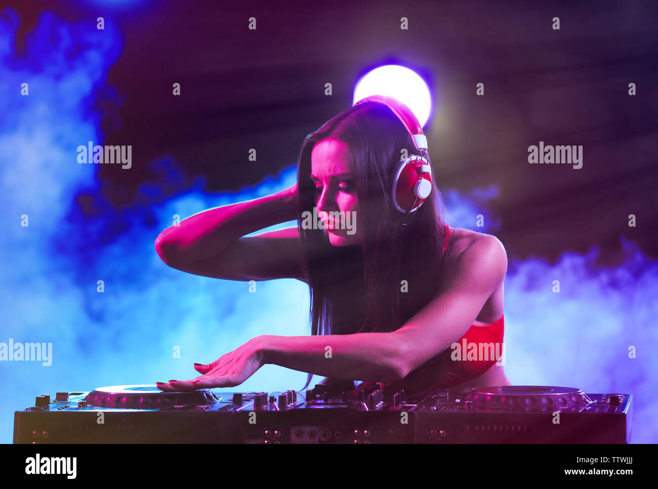 Pretty young DJ playing music in nightclub Stock Photo - Alamy