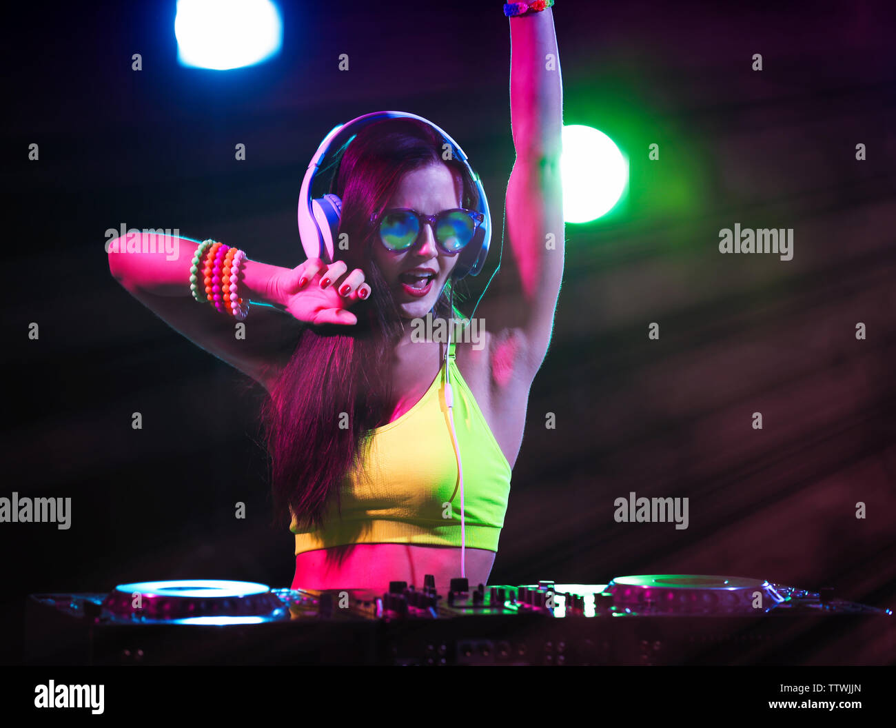 Pretty young DJ playing music in nightclub Stock Photo - Alamy