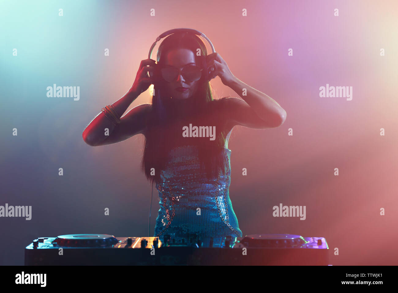 Pretty young DJ playing music in nightclub Stock Photo - Alamy