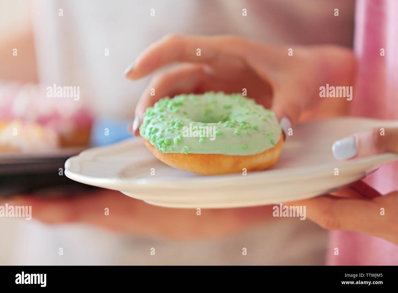 Female hand taking tasty donut from plate, close up view Stock Photo ...