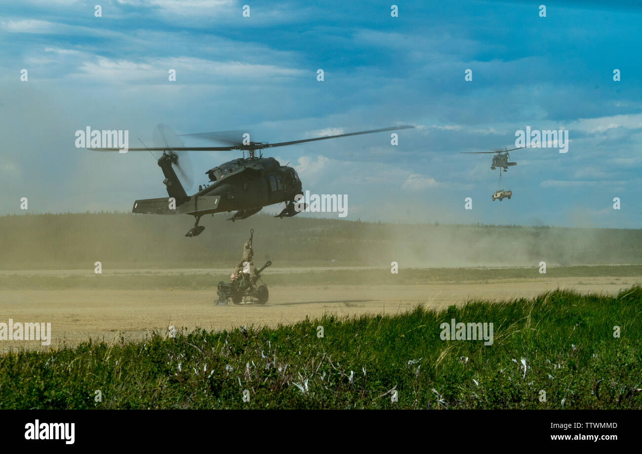 U.S. Army Soldiers attach a M119A3 Howitzer to a UH-60 Black Hawk ...