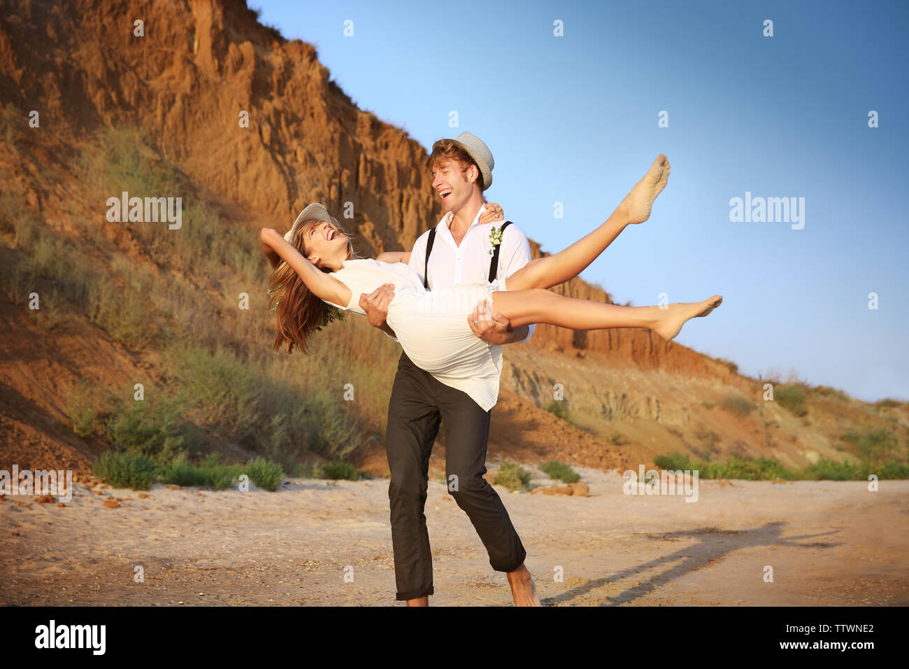 Young man carrying his woman on seashore Stock Photo - Alamy
