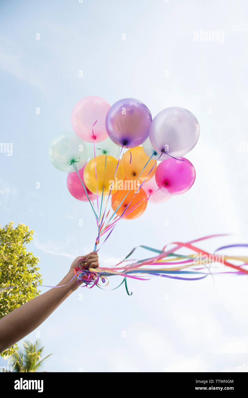 Woman hand holding colorful balloons Stock Photo - Alamy