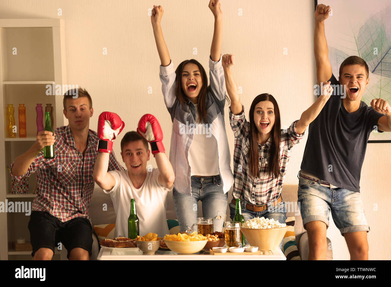 Young fans watching boxing on TV with beer and snacks Stock Photo - Alamy