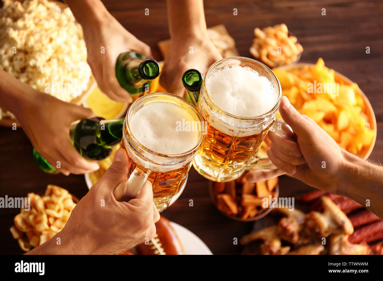Hands clinking beer mugs and bottles at party, close up Stock Photo - Alamy